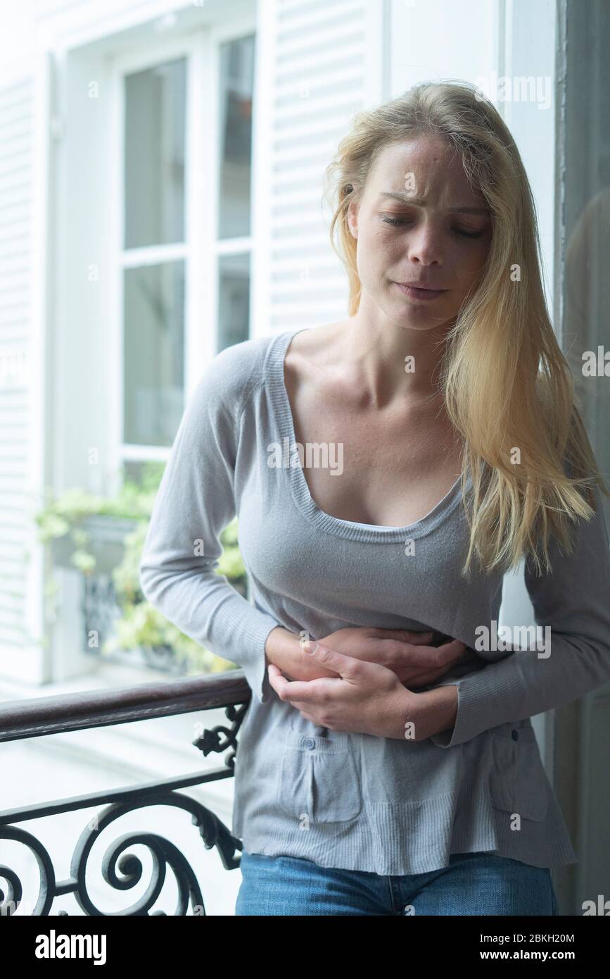 Young woman suffering from stomach cramps Stock Photo - Alamy