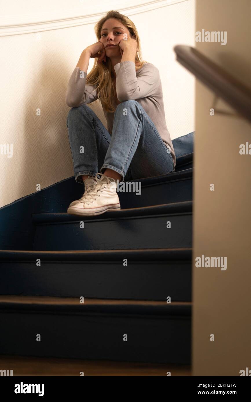 Young woman sitting on steps Stock Photo - Alamy