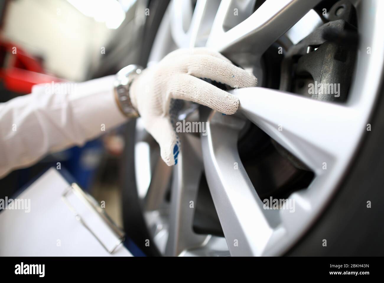 Close-up gloved hand touches the cap car wheel Stock Photo - Alamy
