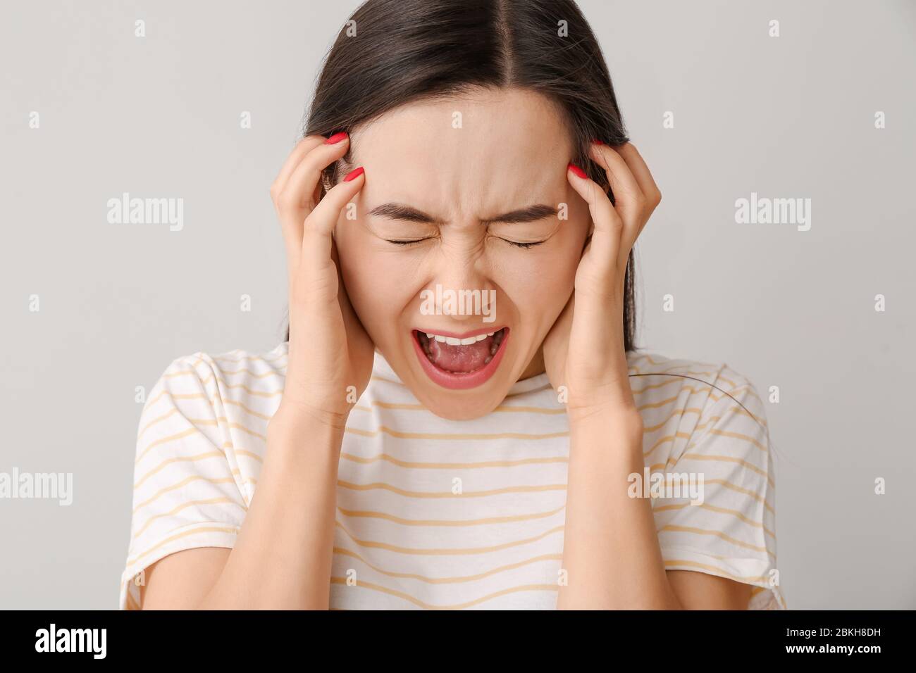 Portrait of screaming young woman on grey background Stock Photo - Alamy