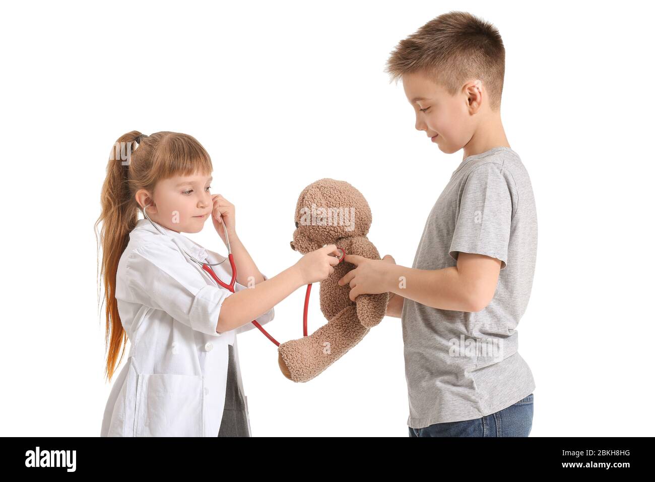 Cute little doctor with boy and teddy bear on white background Stock ...
