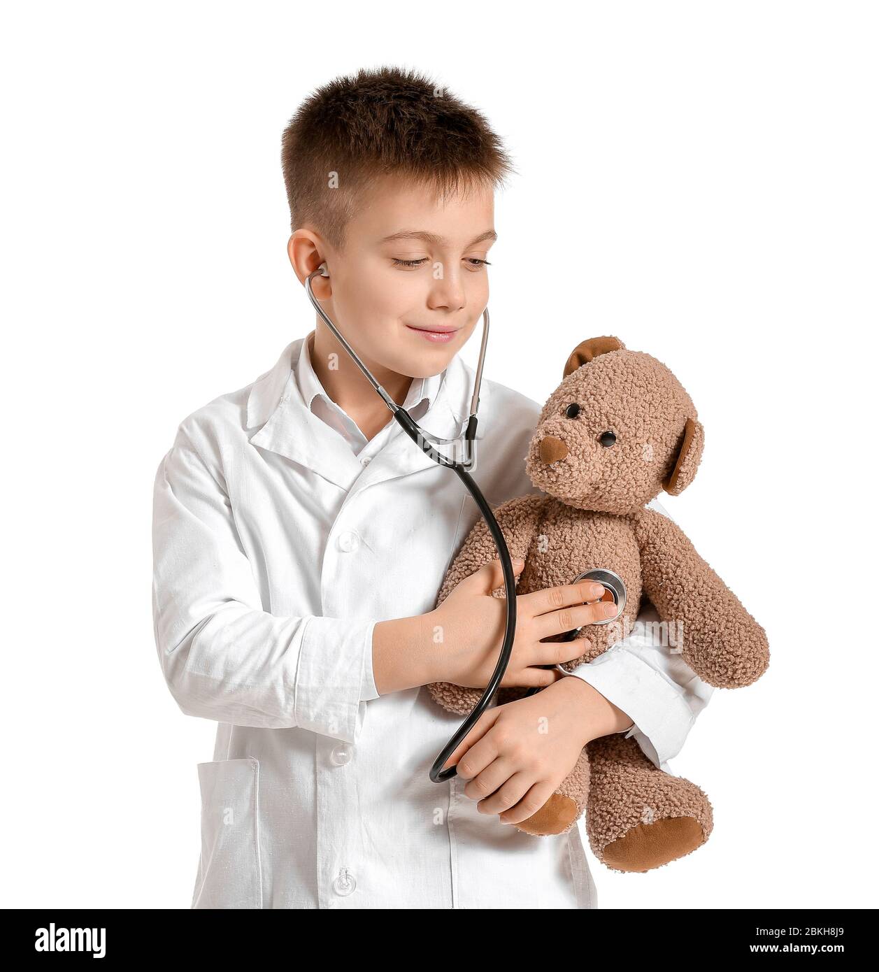 Cute little doctor with teddy bear on white background Stock Photo - Alamy