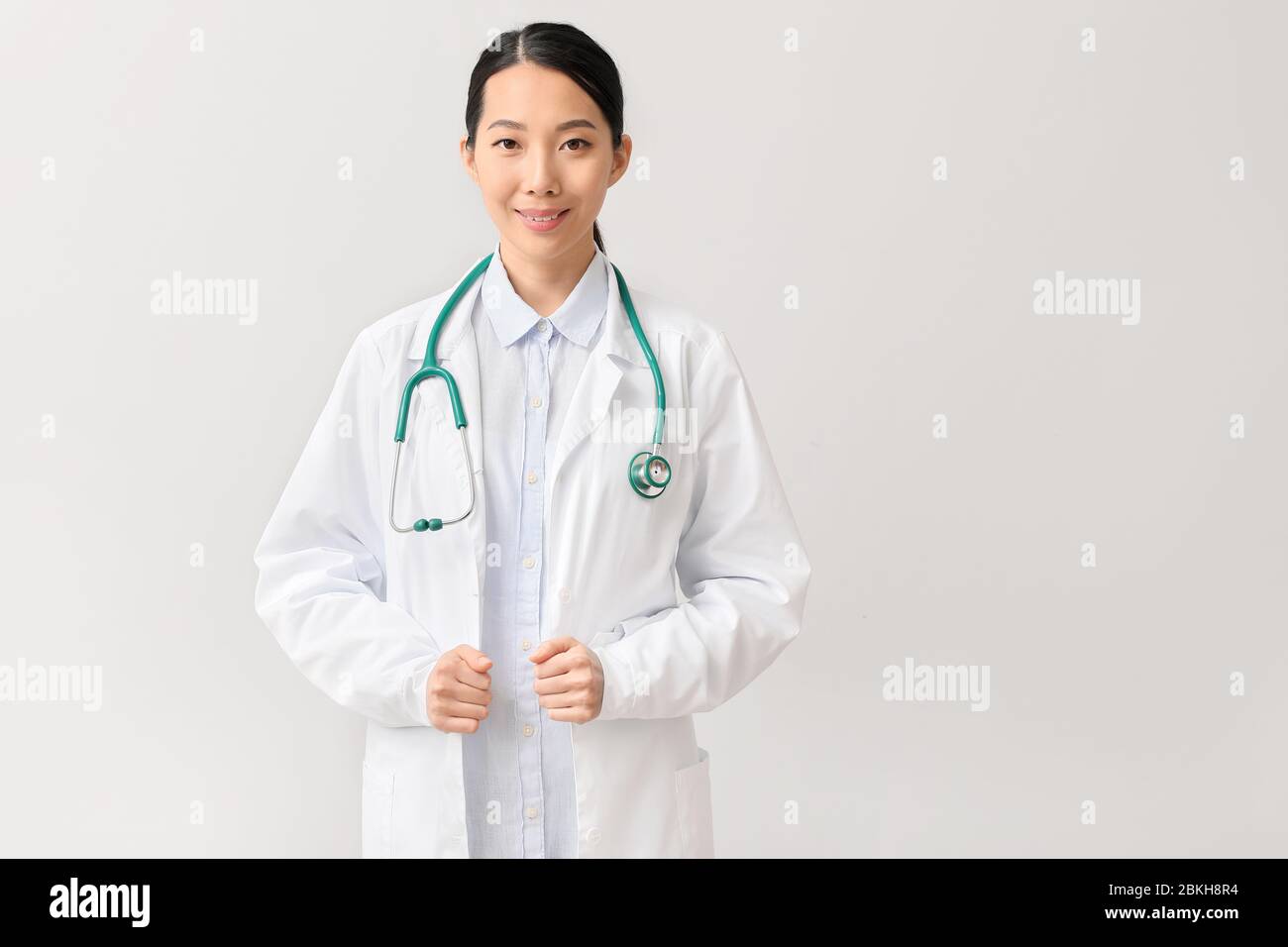 Female Asian doctor on light background Stock Photo - Alamy