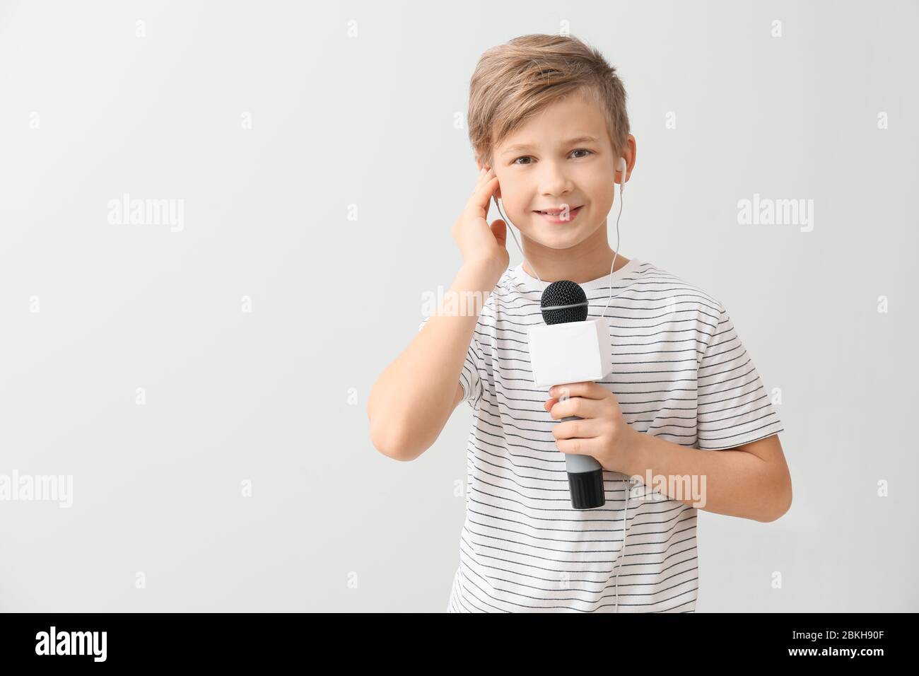 Little journalist with microphone on white background Stock Photo - Alamy