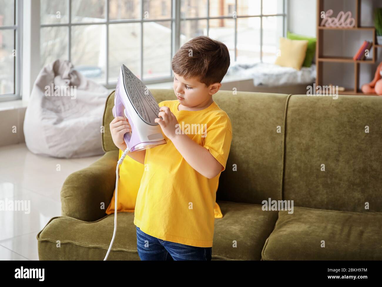 Little boy playing with electric iron at home Stock Photo - Alamy