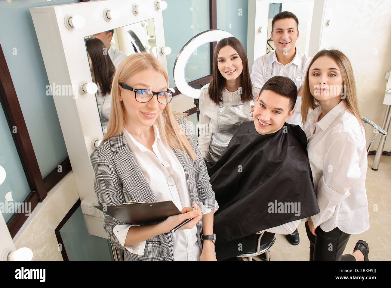 Professional hairdresser teaching young people in salon Stock Photo - Alamy