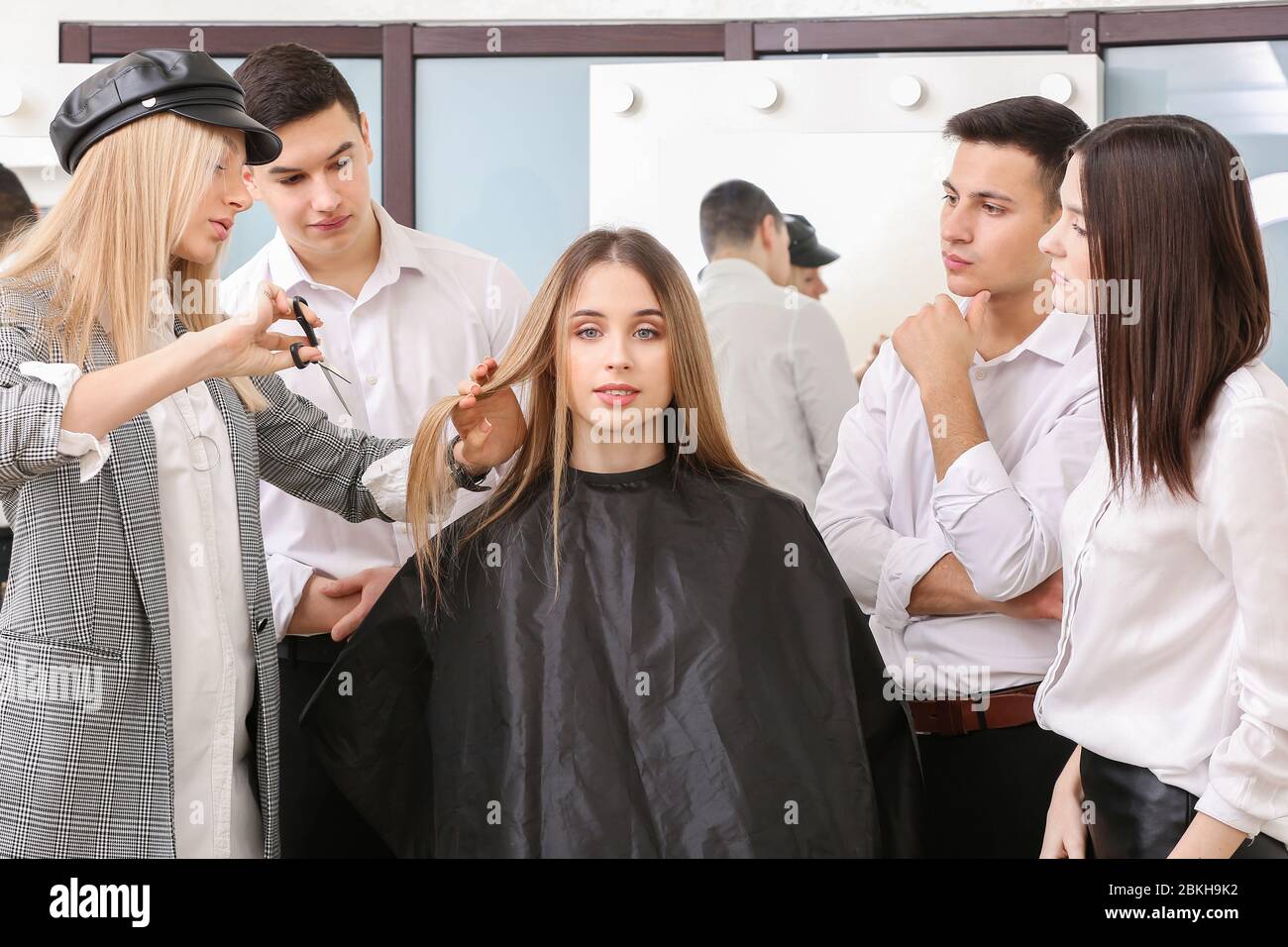 Professional hairdresser teaching young people in salon Stock Photo - Alamy