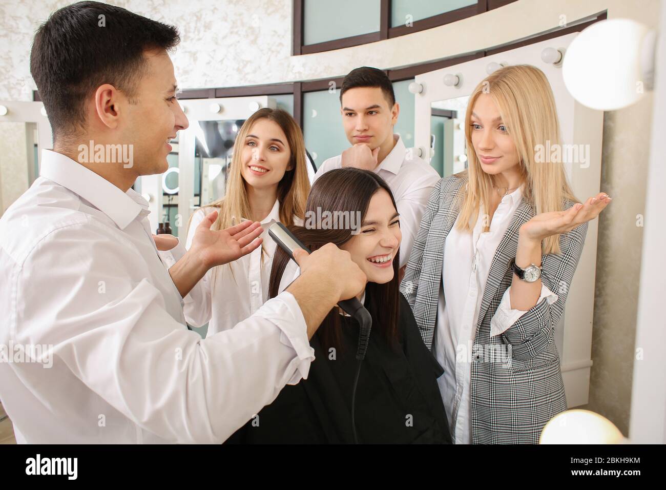 Young people with professional hairdresser and model during courses in ...