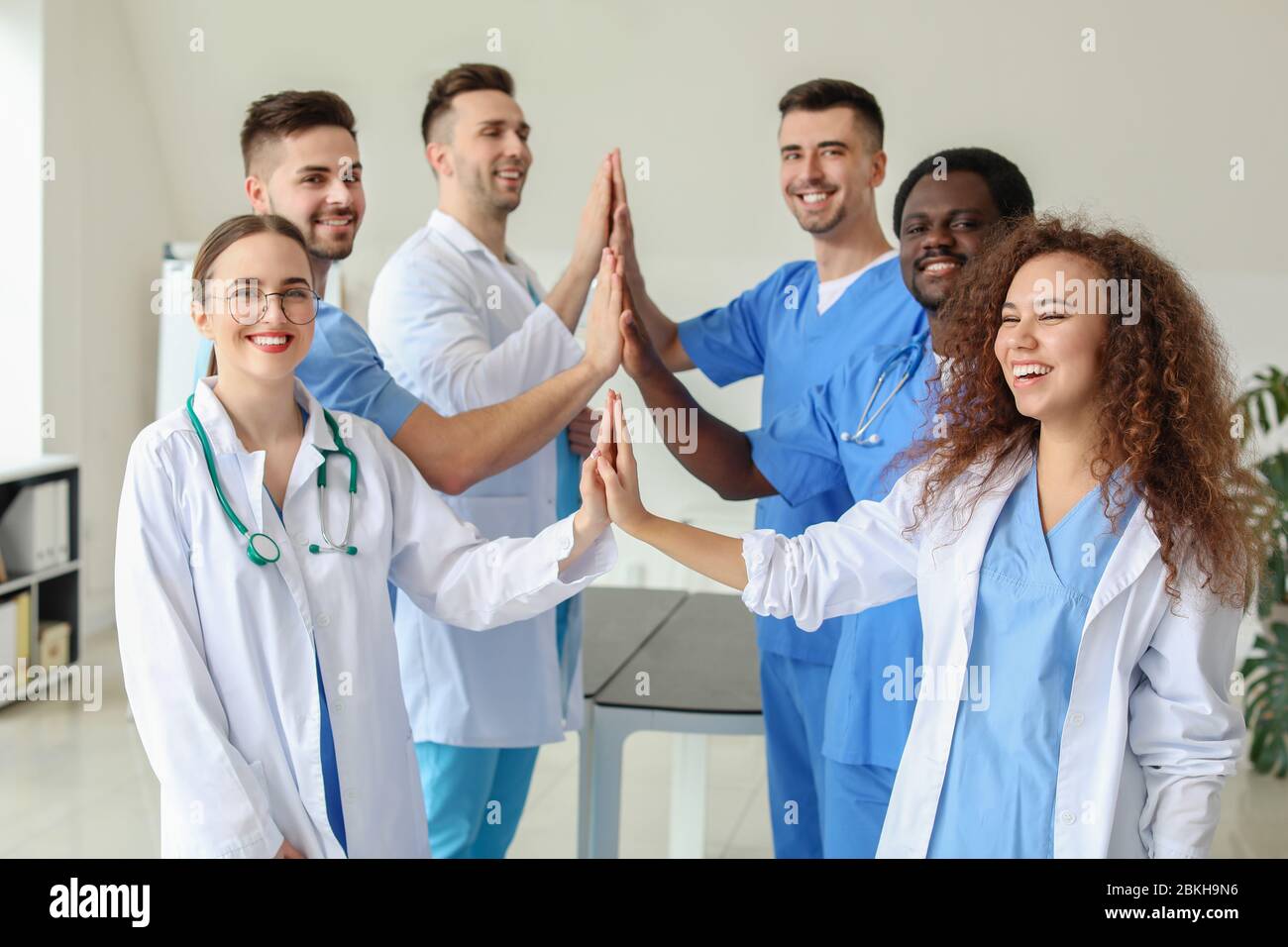 Group of doctors putting hands together in clinic. Unity concept Stock ...