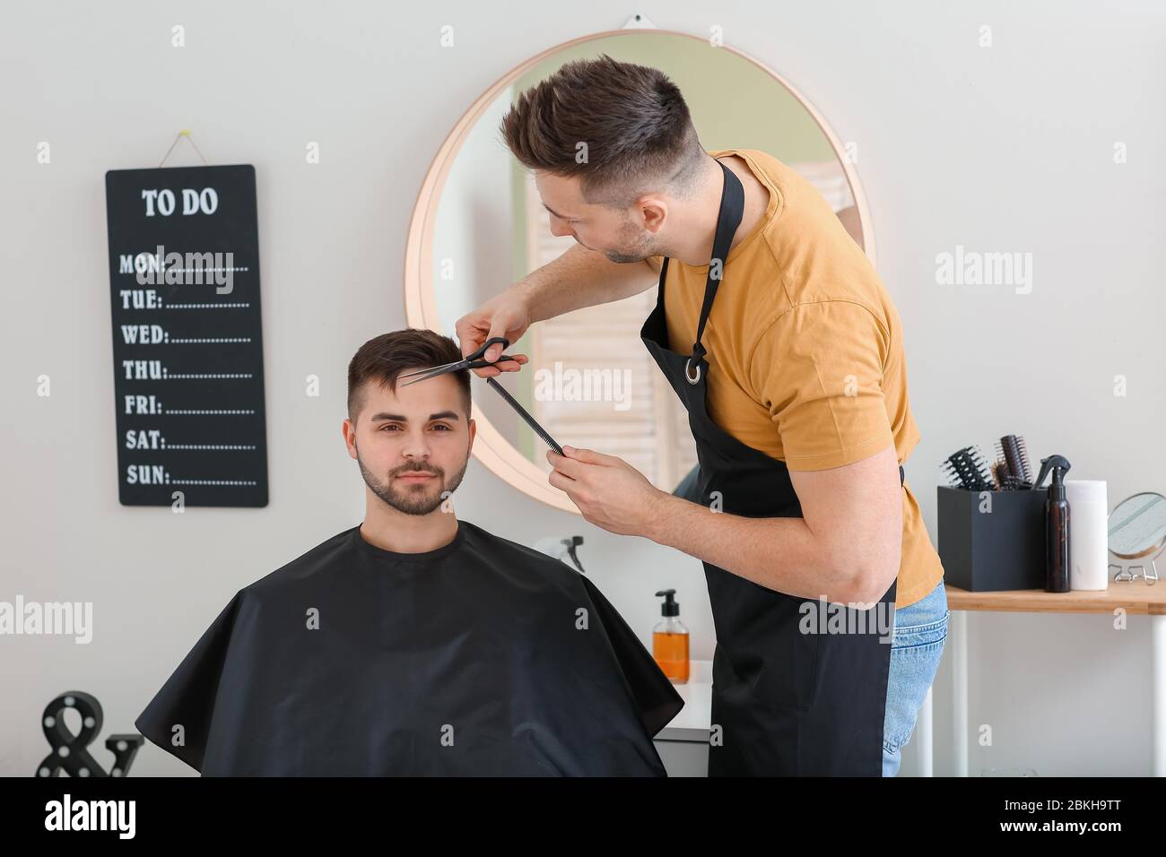 Male hairdresser working with client in salon Stock Photo - Alamy