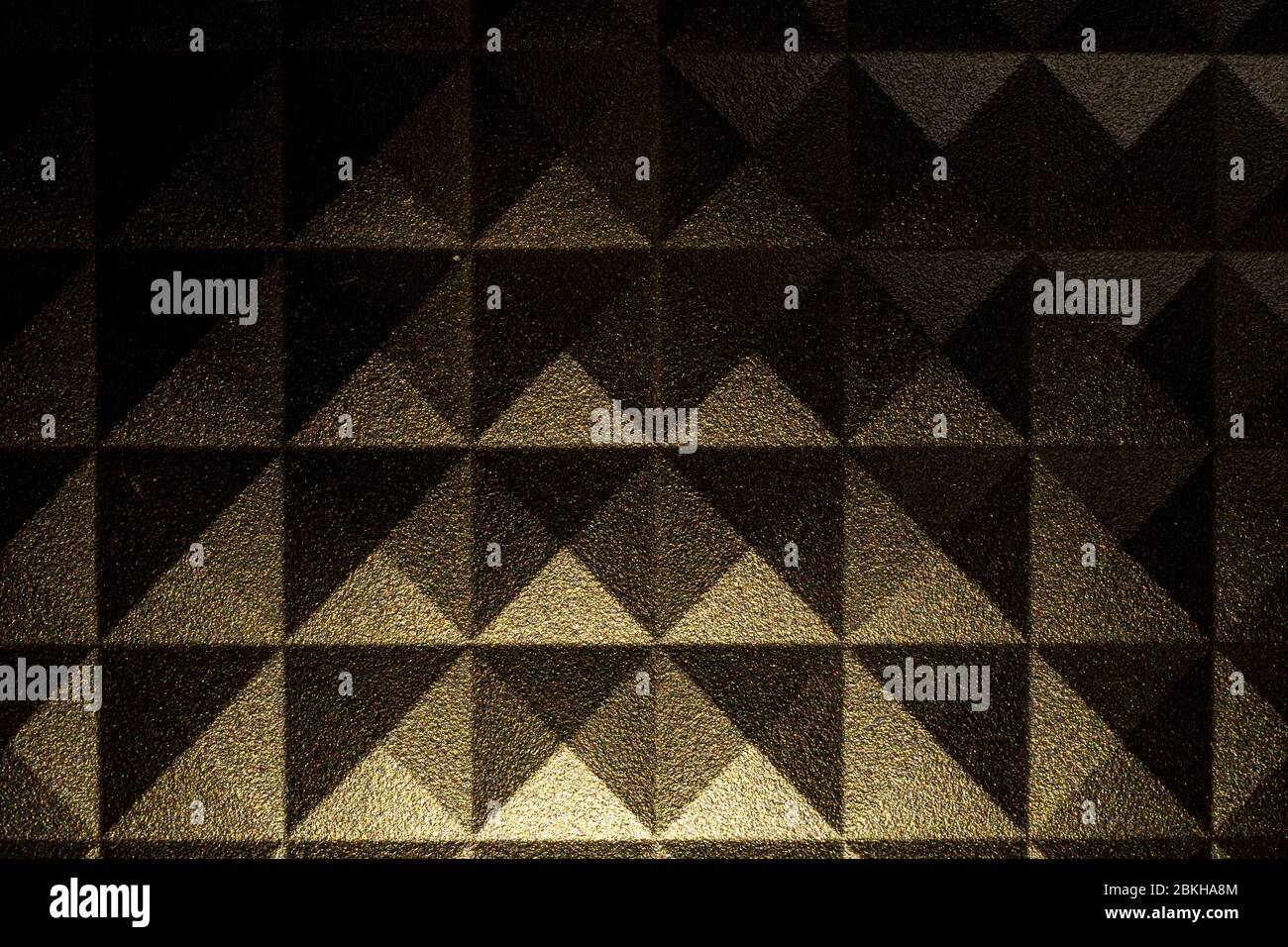 Pyramid pattern background with a rough surface and contrasting light ...