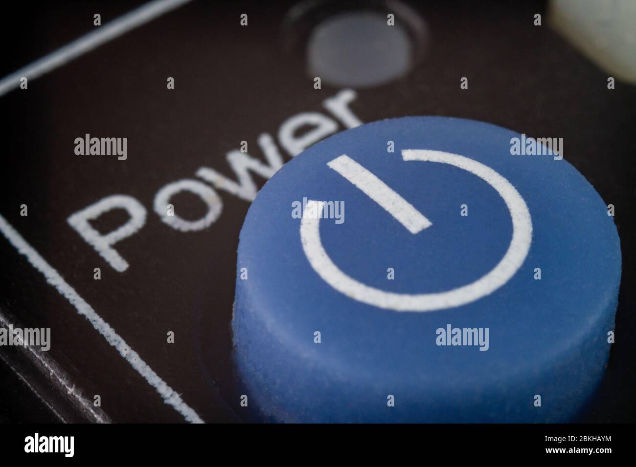 Extreme macro shot of a blue power button on a remote control for a TV ...