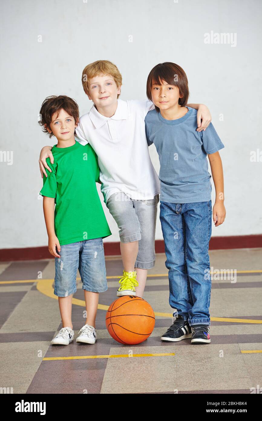Three boyfriends are standing with a basketball in the school ...