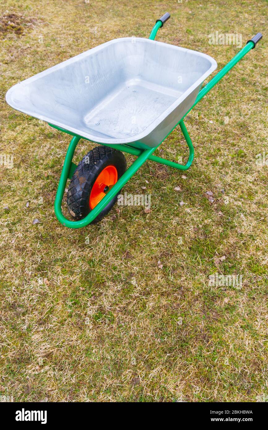 Garden metal wheelbarrow with green reinforced frame on one wheel in ...