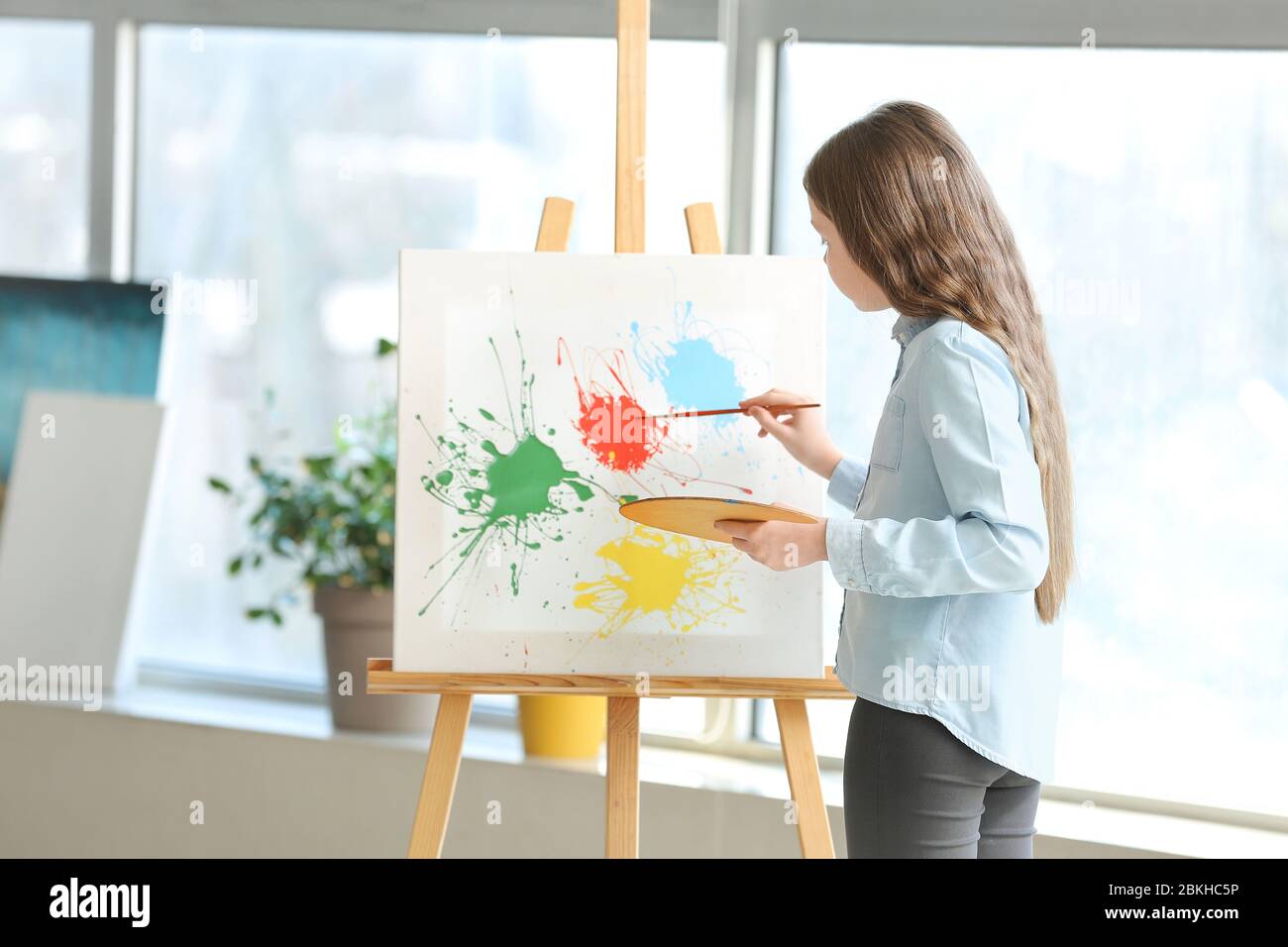 Cute girl painting at school Stock Photo - Alamy