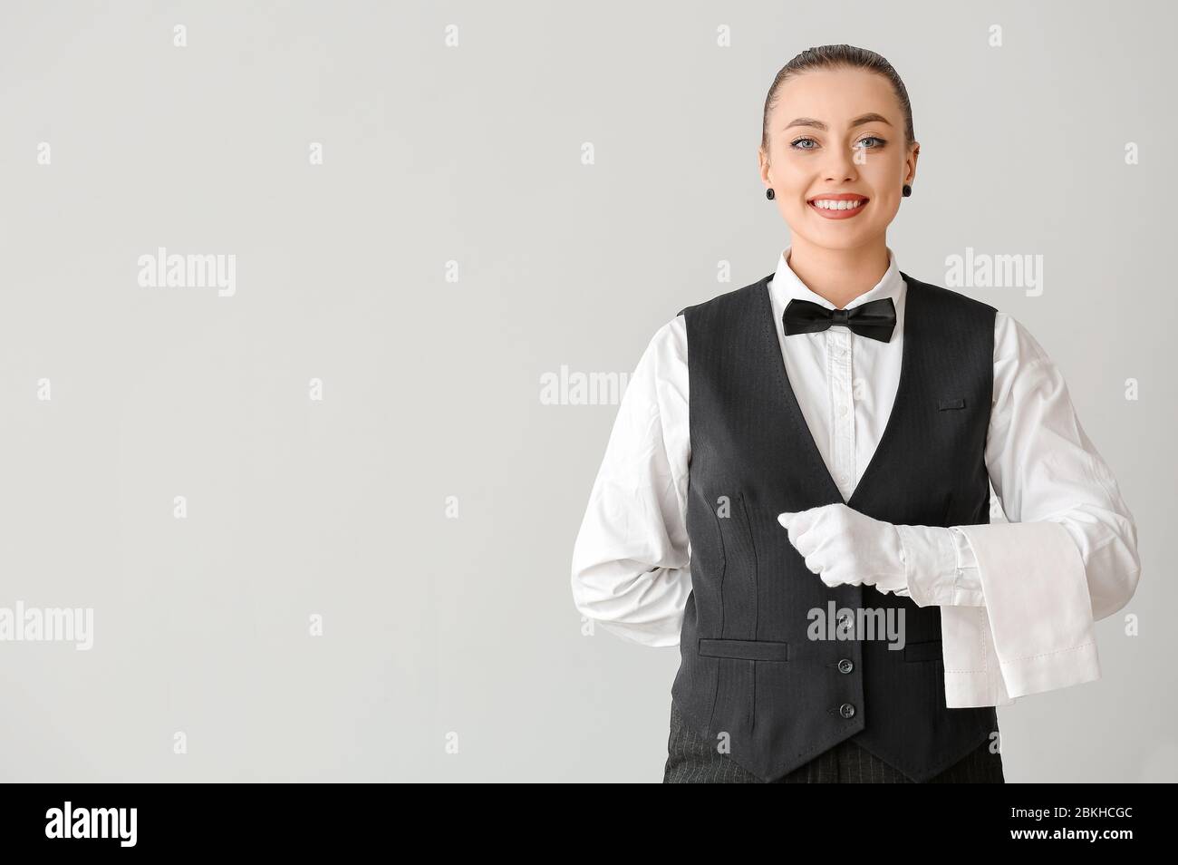 Beautiful female waiter on grey background Stock Photo - Alamy