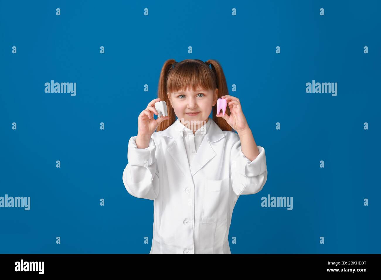 Little dentist with plastic teeth models on color background Stock ...