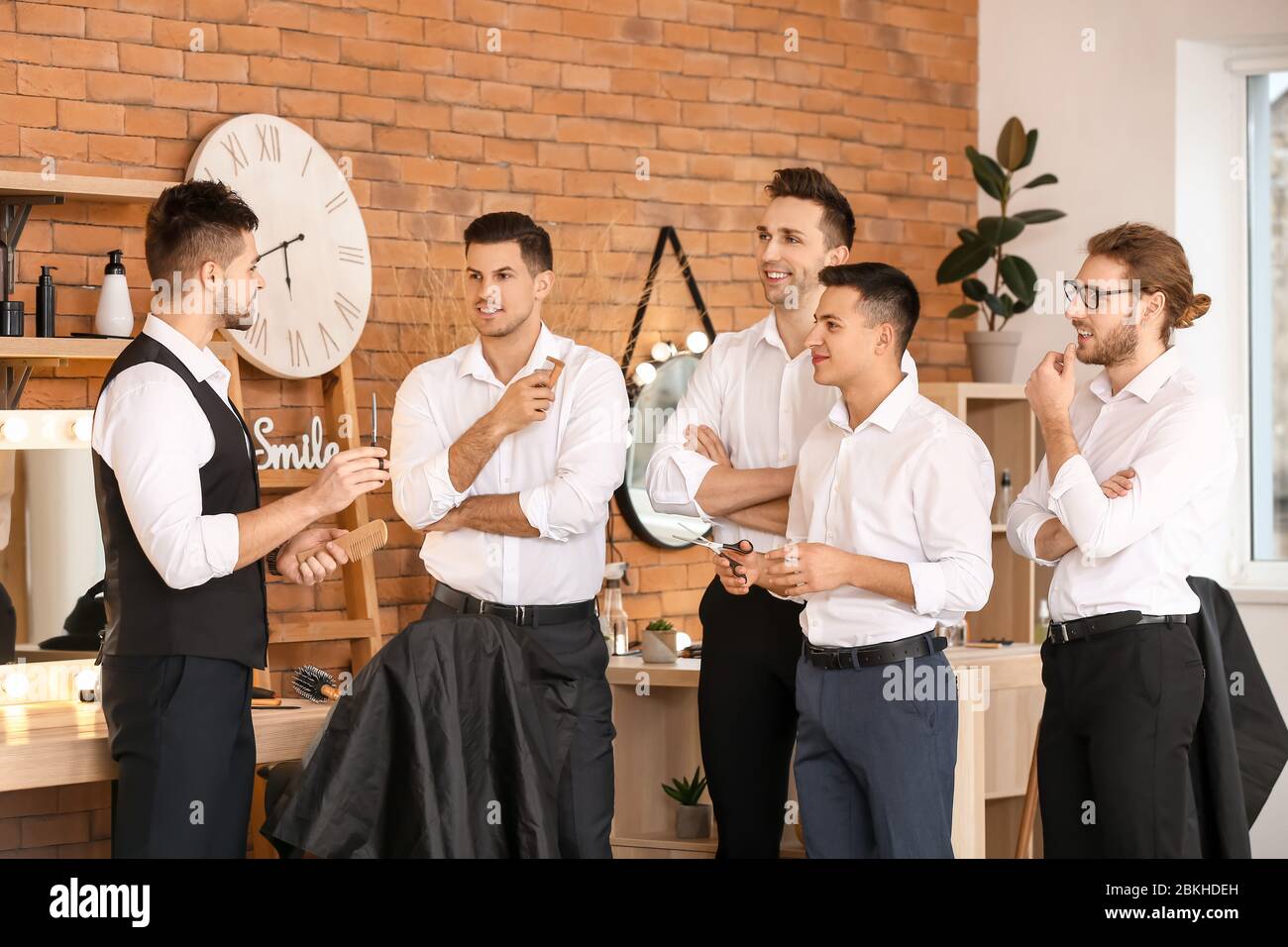 Professional hairdresser teaching young men in salon Stock Photo - Alamy