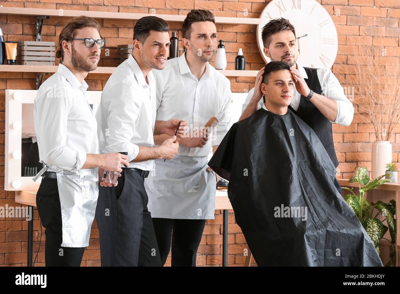 Professional hairdresser teaching young men in salon Stock Photo - Alamy