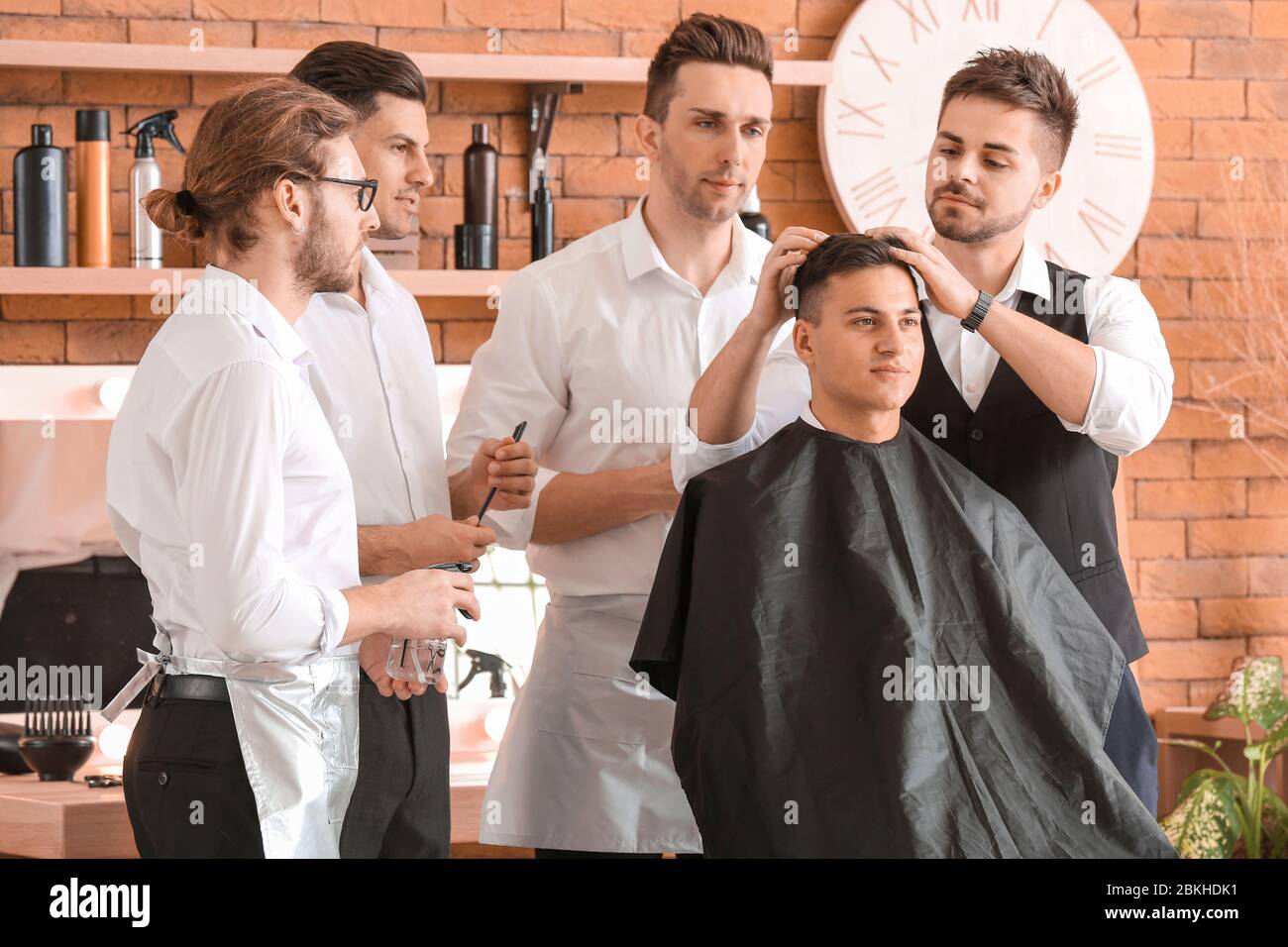 Professional hairdresser teaching young men in salon Stock Photo - Alamy