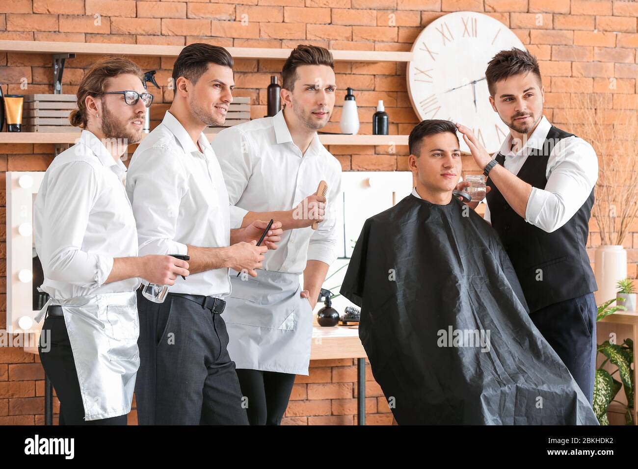Professional hairdresser teaching young men in salon Stock Photo - Alamy