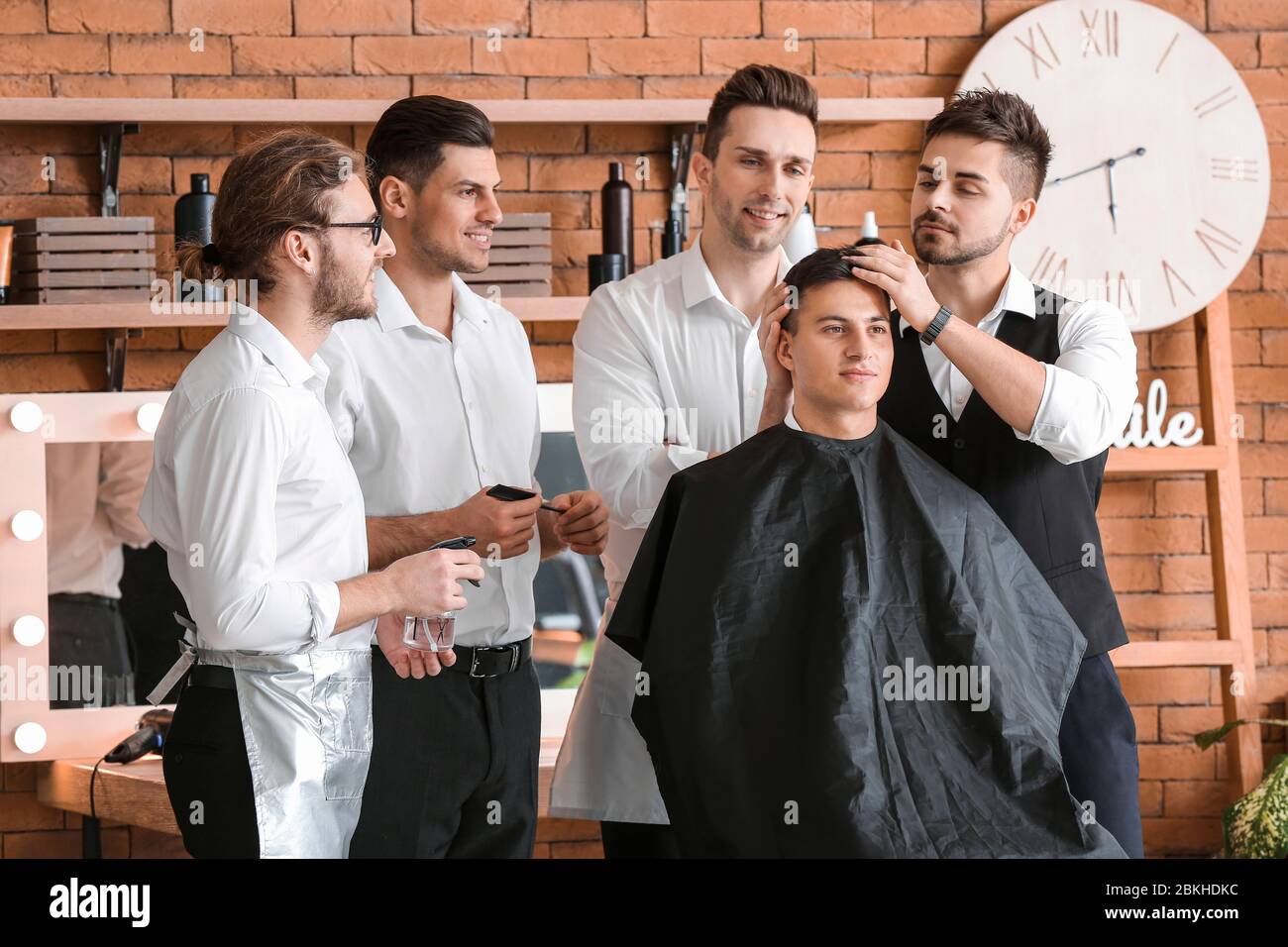 Professional hairdresser teaching young men in salon Stock Photo - Alamy