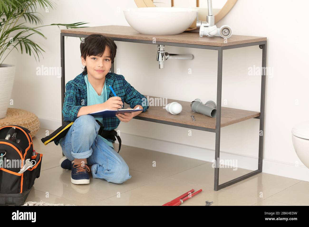Portrait of little plumber in restroom Stock Photo - Alamy