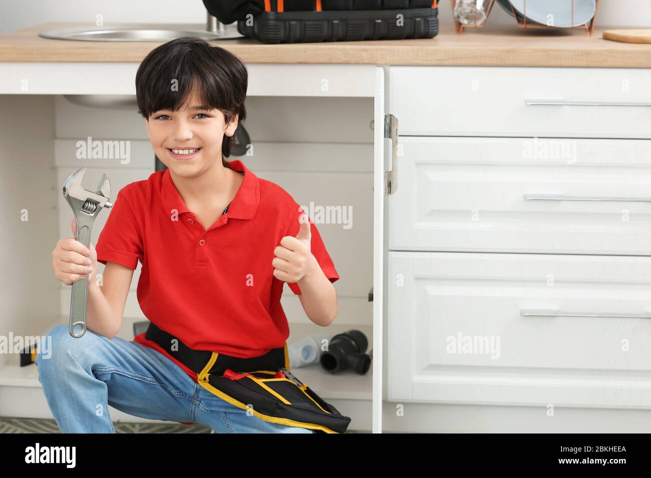 Portrait of little plumber in kitchen Stock Photo - Alamy