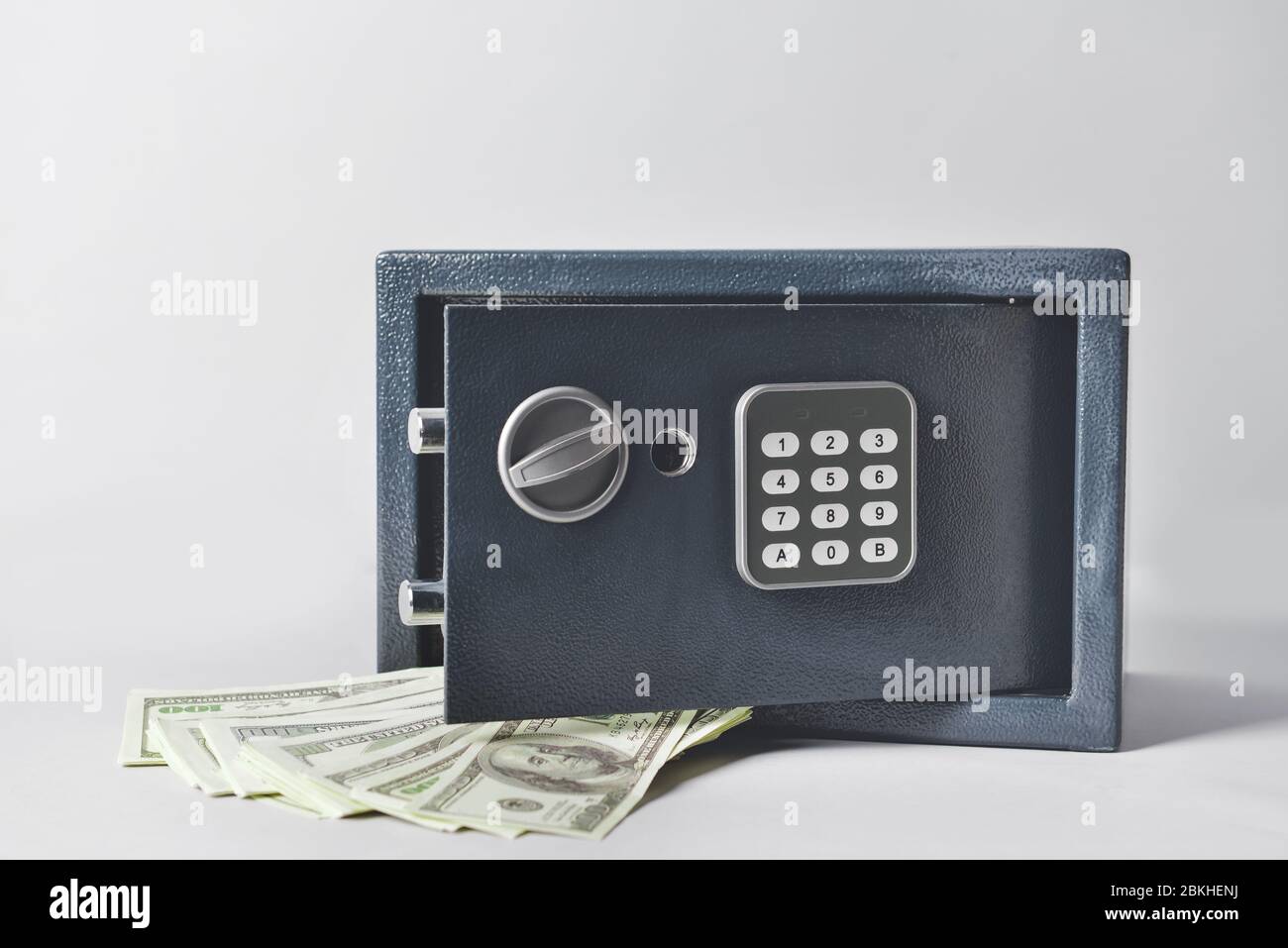 Modern safe with dollar banknotes on light background Stock Photo - Alamy
