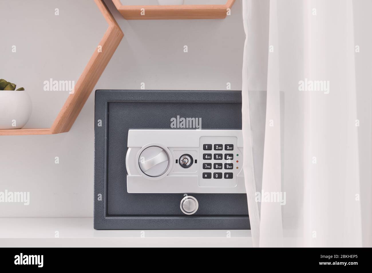 Modern safe on shelf in room Stock Photo - Alamy
