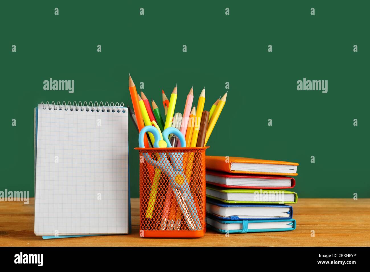 Holder with stationery on table in classroom Stock Photo - Alamy