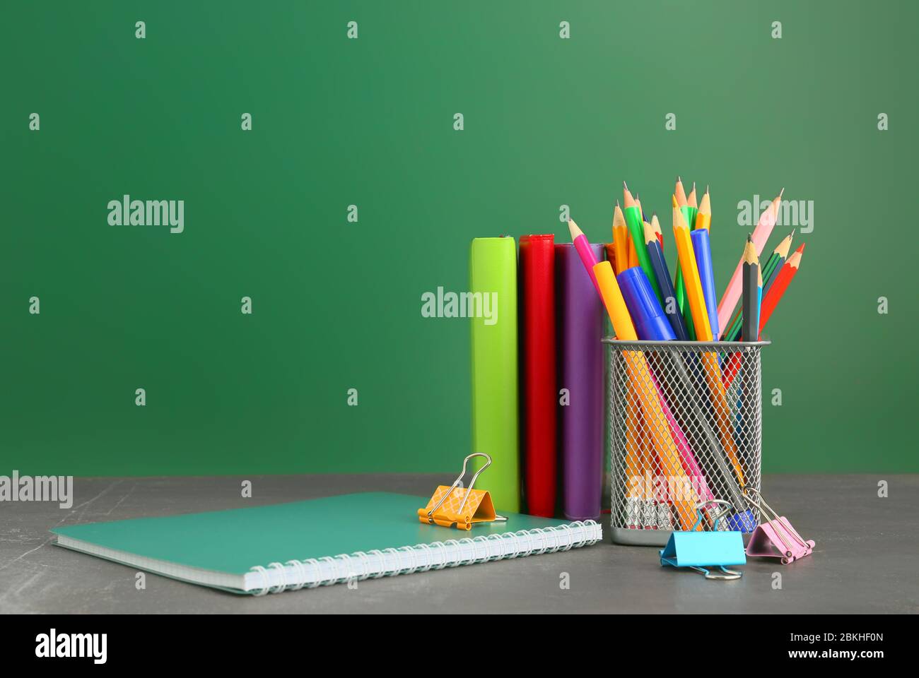 Holder with stationery on table in classroom Stock Photo - Alamy