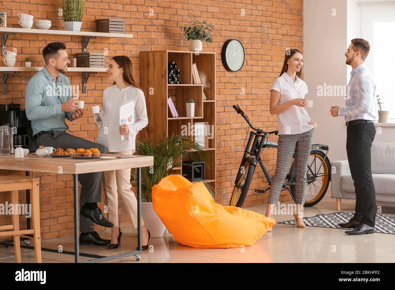 Colleagues drinking coffee in kitchen of office Stock Photo - Alamy