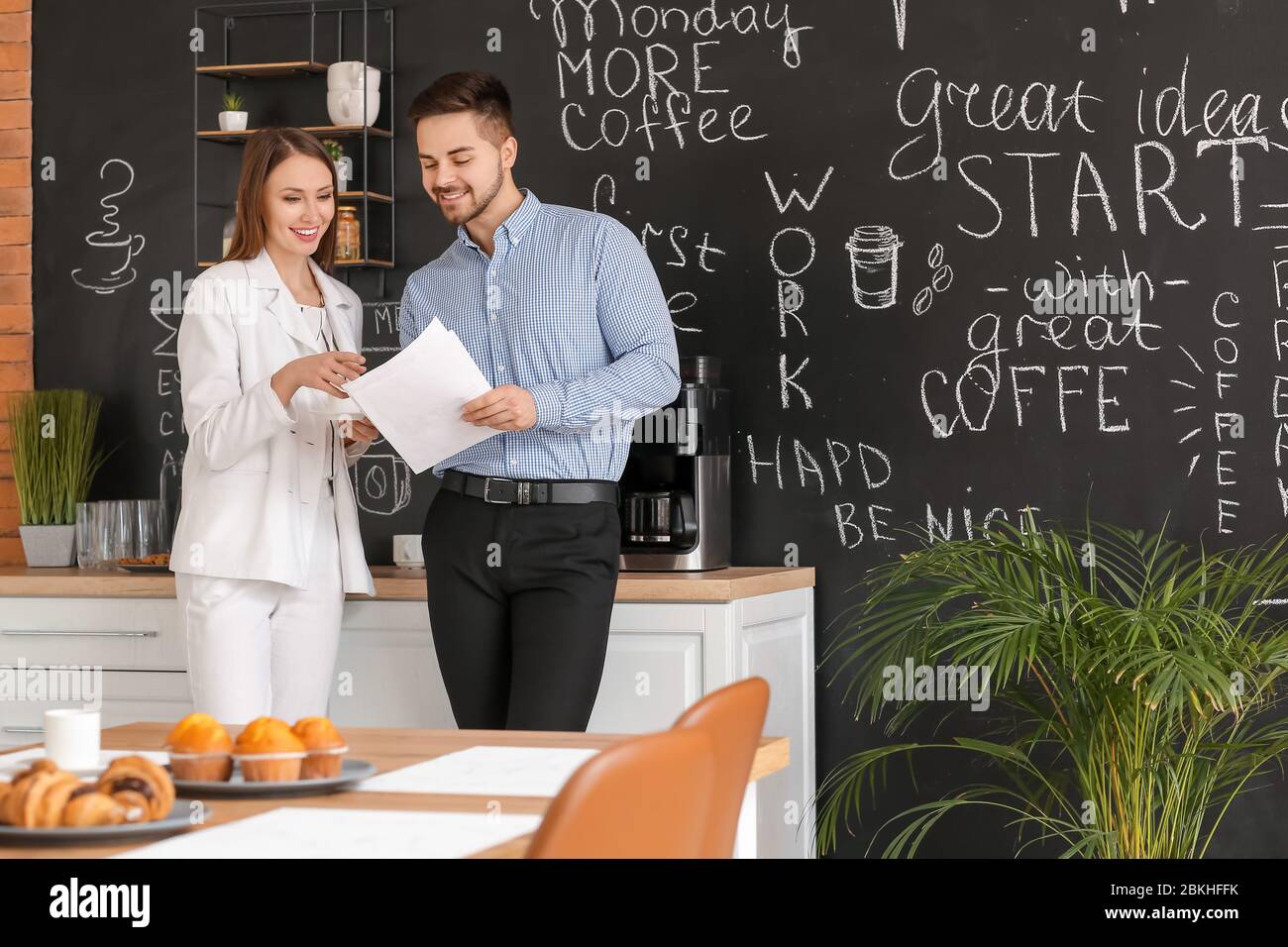 Colleagues drinking coffee in kitchen of office Stock Photo - Alamy
