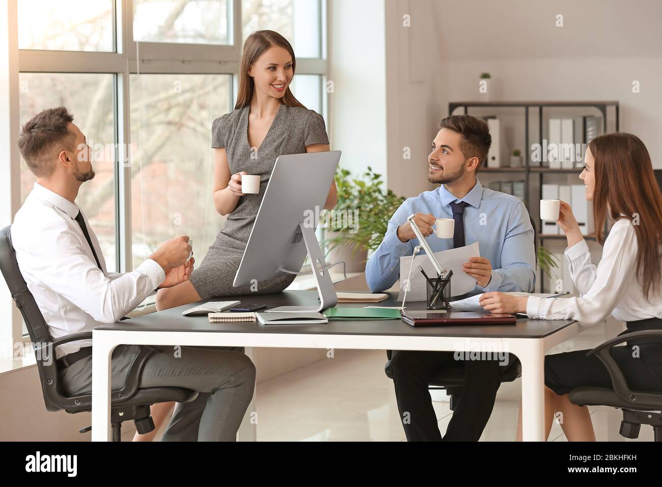 Colleagues drinking coffee during work in office Stock Photo - Alamy
