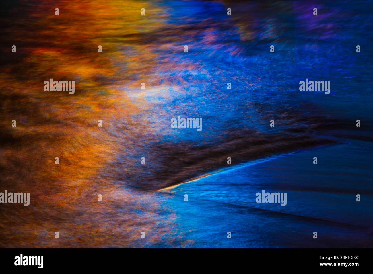 Warm and cool colors mixing and reflecting on the surface of water with ...