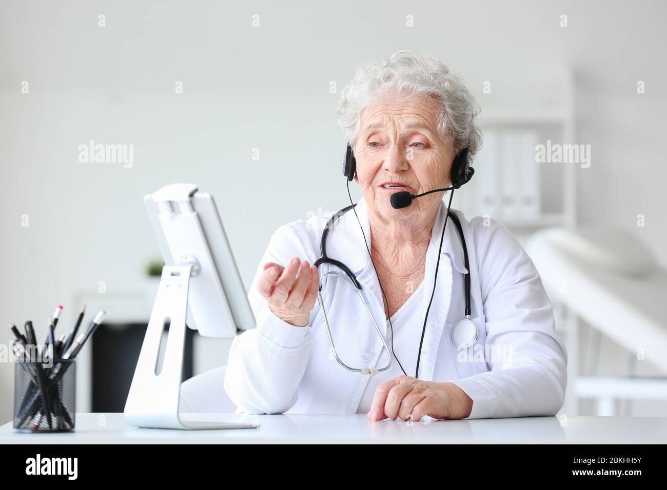 Female doctor giving a consultation online in clinic Stock Photo - Alamy