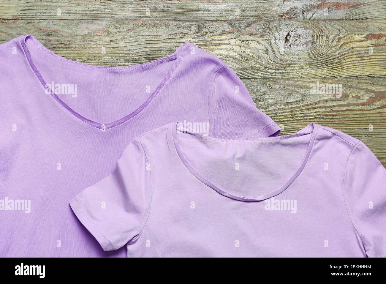 Different stylish t-shirts on wooden background Stock Photo - Alamy