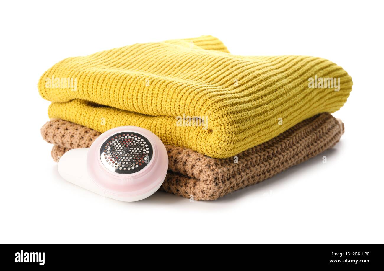 Modern fabric shaver and clothes on white background Stock Photo - Alamy