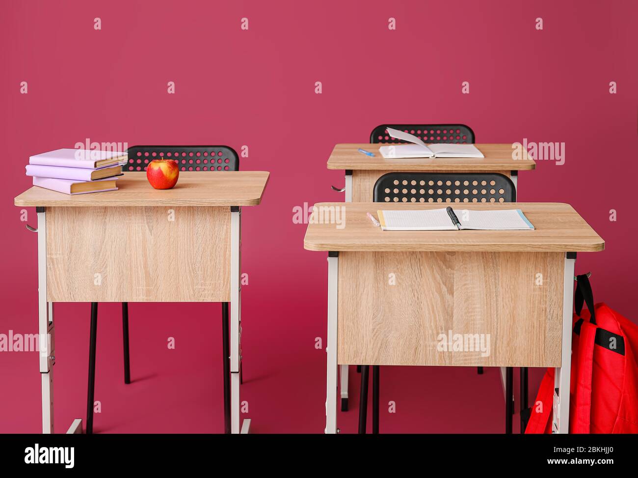 Modern school desks on color background Stock Photo - Alamy