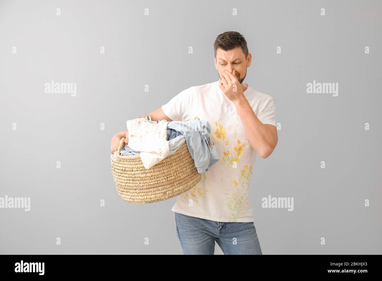 Displeased man with dirty clothes on light background Stock Photo - Alamy