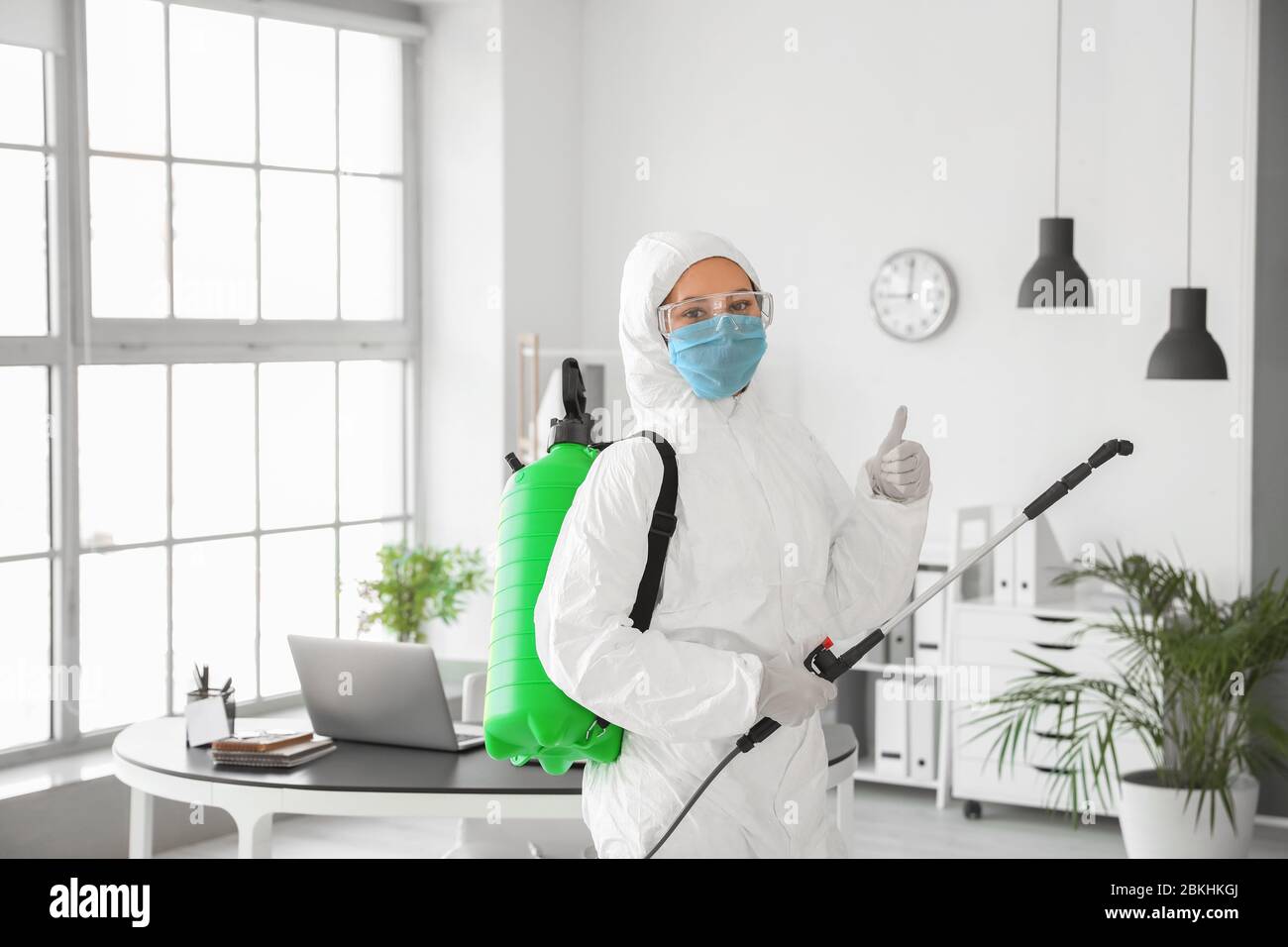 Worker in biohazard suit disinfecting office Stock Photo - Alamy