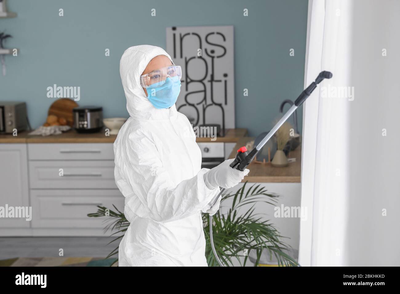 Worker in biohazard suit disinfecting house Stock Photo - Alamy