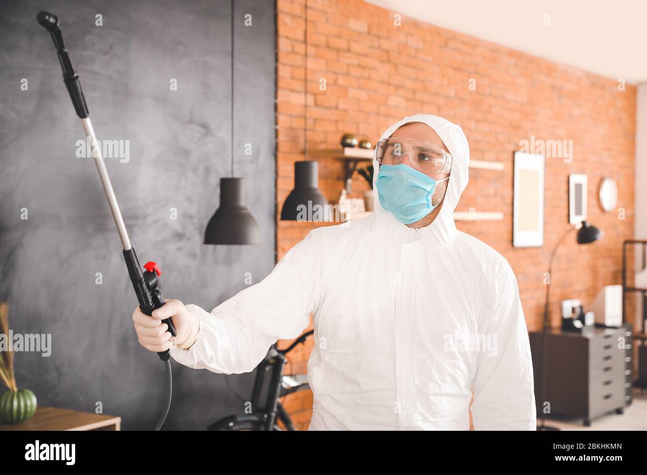 Worker in biohazard suit disinfecting house Stock Photo - Alamy
