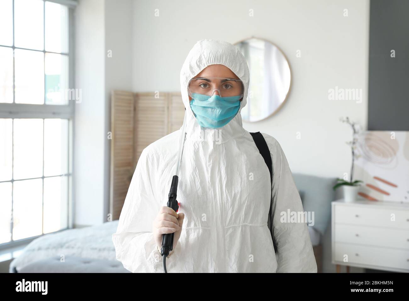 Worker in biohazard suit disinfecting house Stock Photo - Alamy