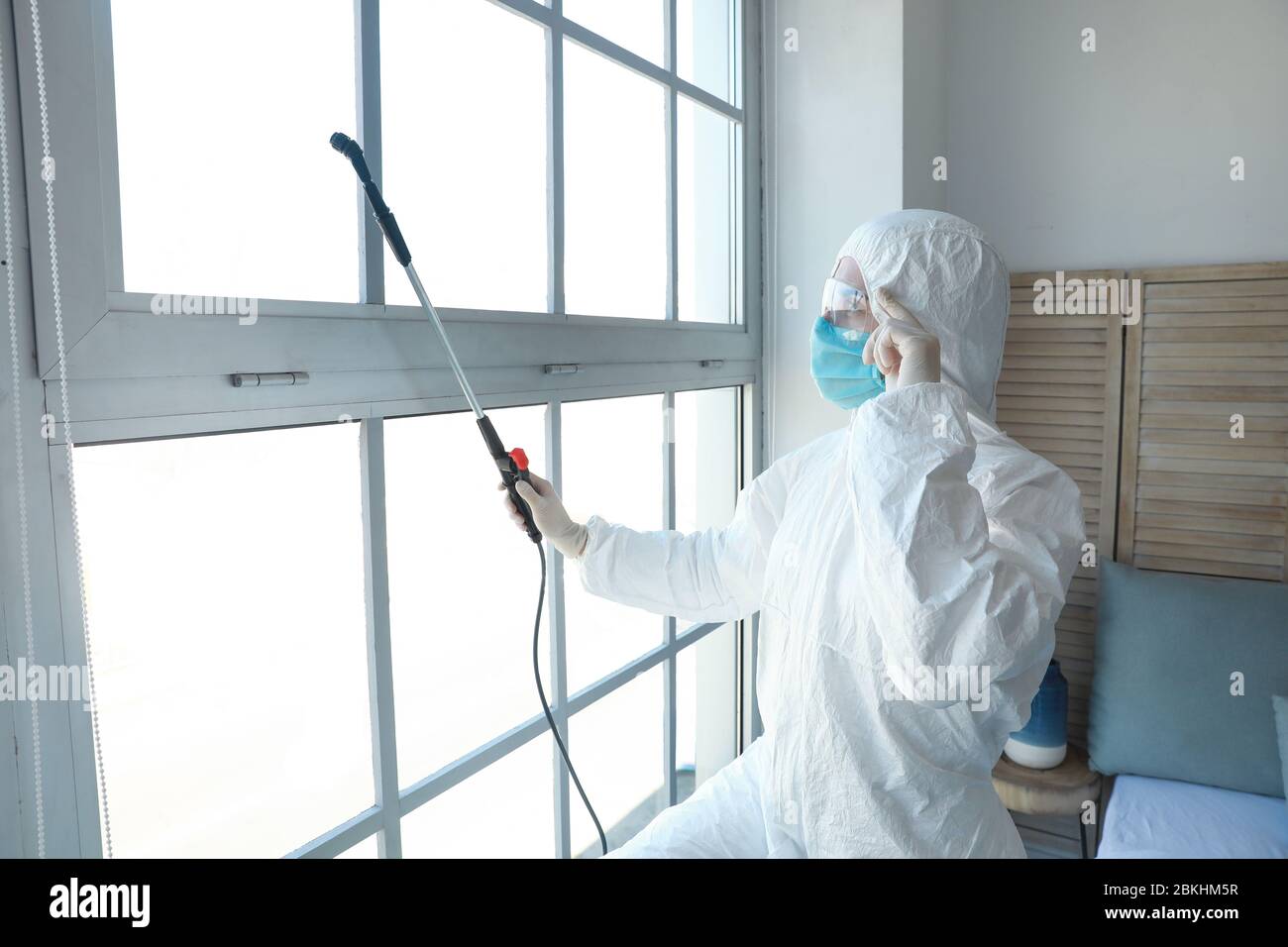 Worker in biohazard suit disinfecting house Stock Photo - Alamy