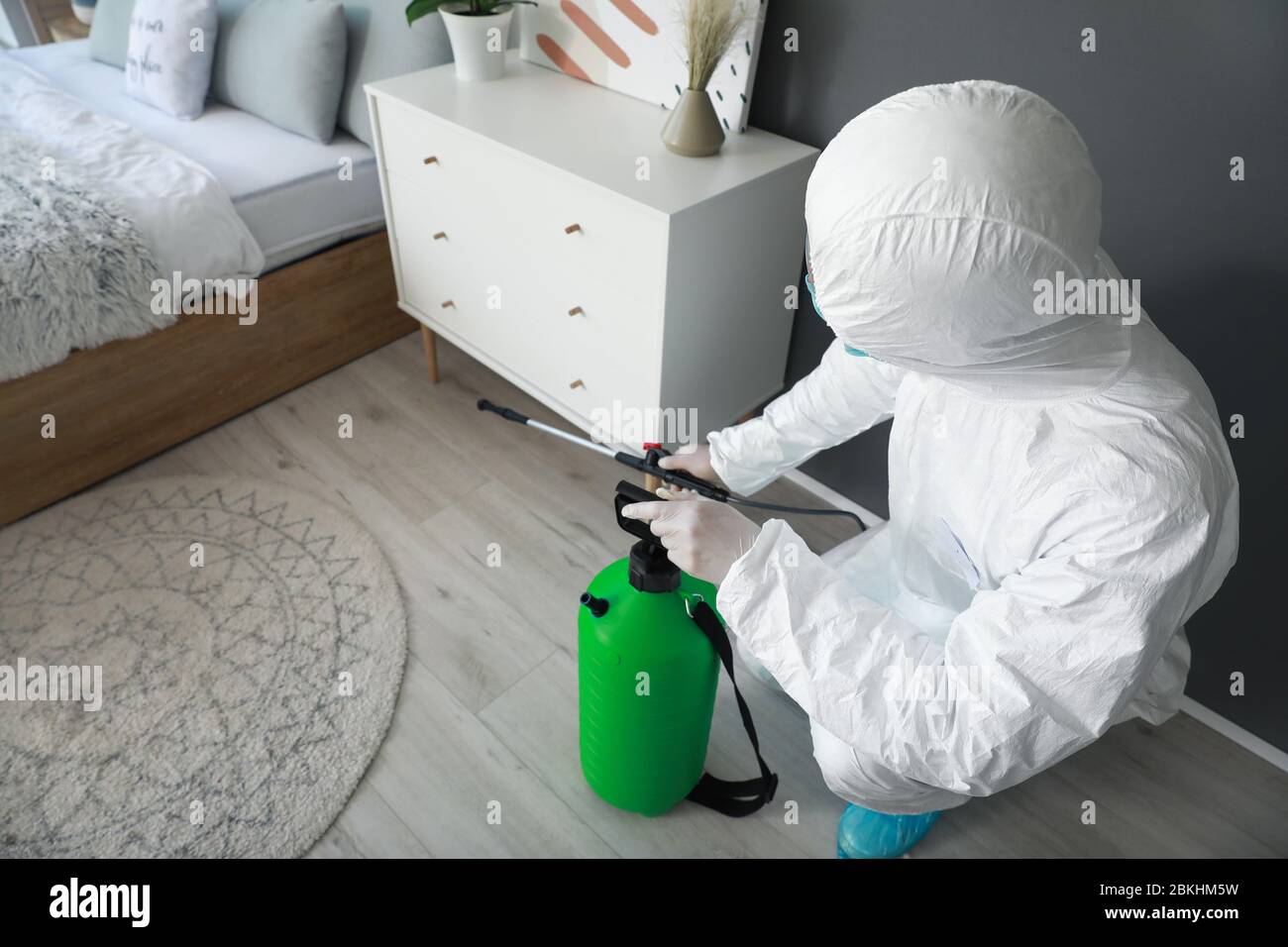 Worker in biohazard suit disinfecting house Stock Photo - Alamy
