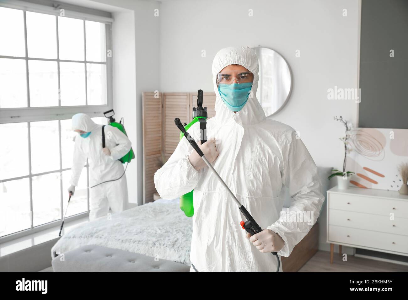 Workers in biohazard suits disinfecting house Stock Photo - Alamy