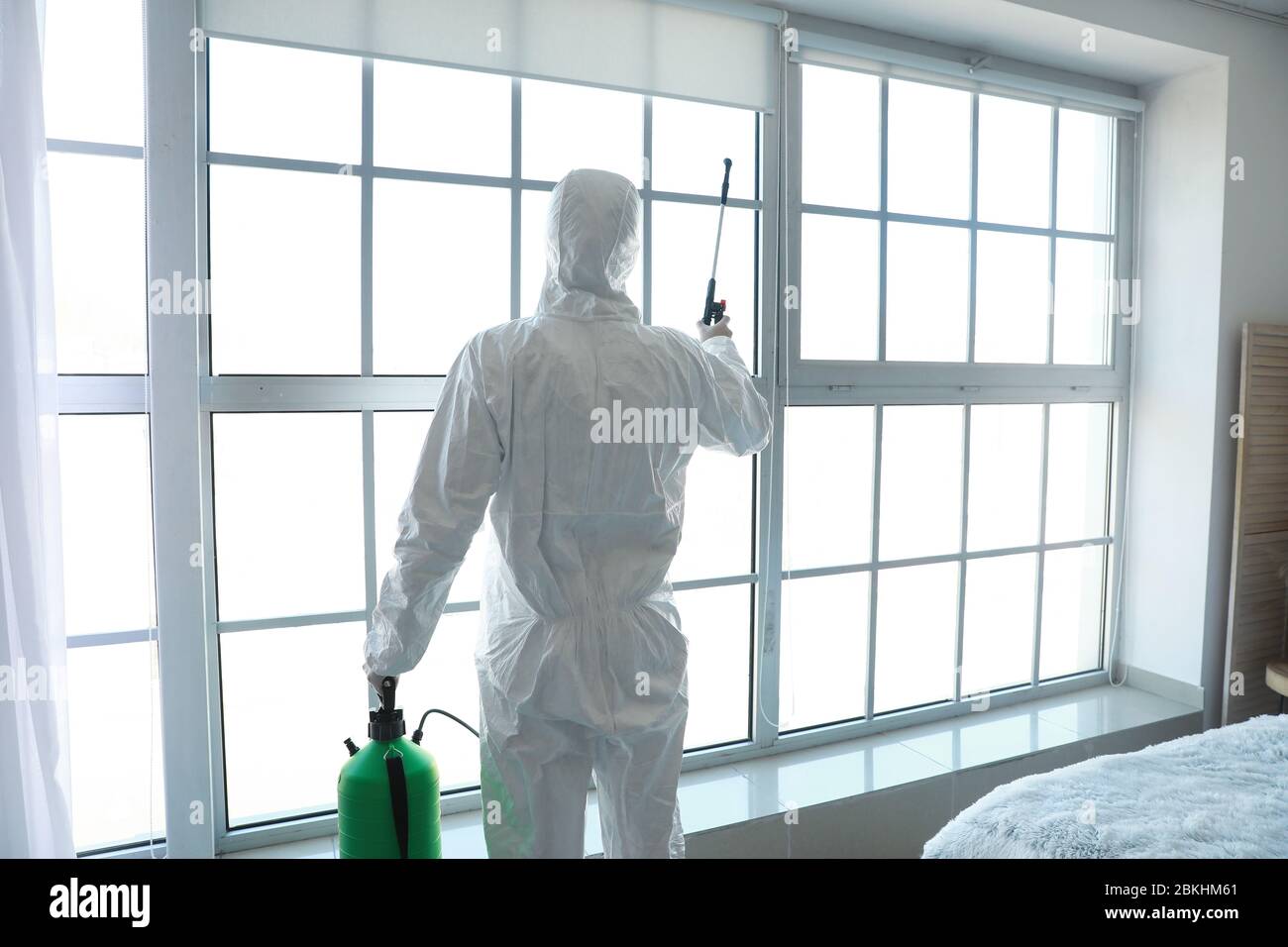 Worker in biohazard suit disinfecting house Stock Photo - Alamy