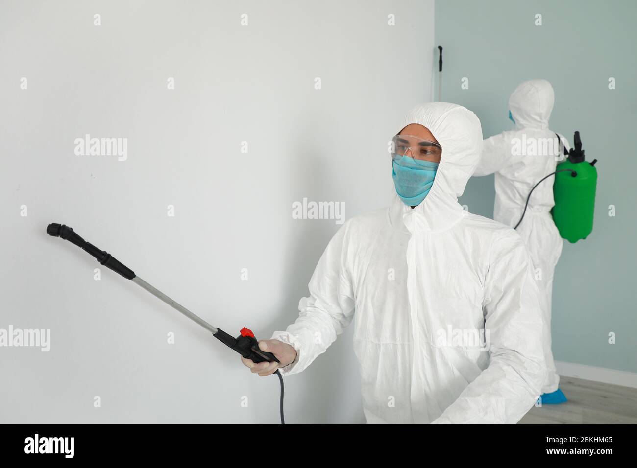 Workers in biohazard suits disinfecting house Stock Photo - Alamy